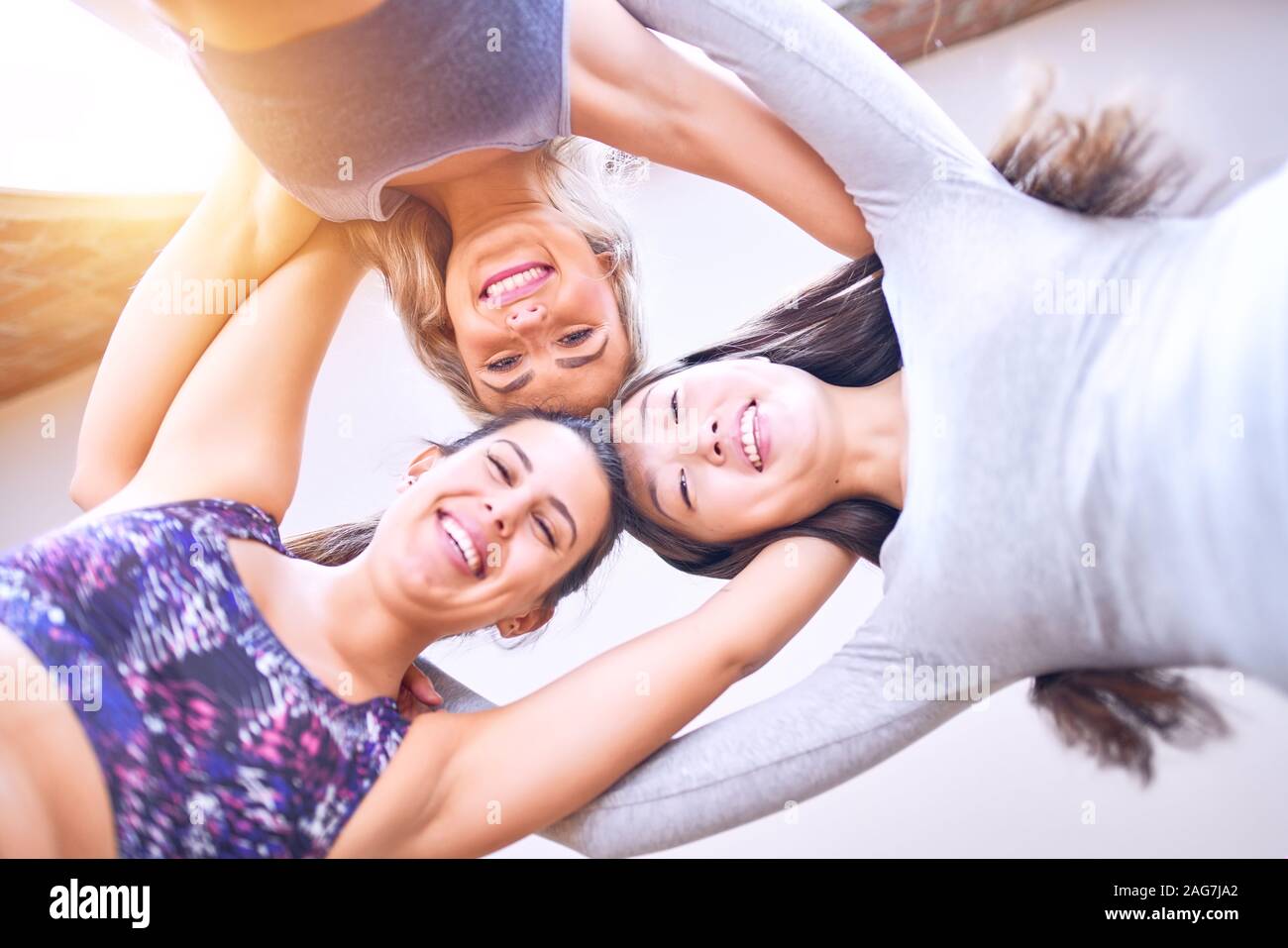 Young beautiful group of sportswomen smiling happy. Standing hugging ...