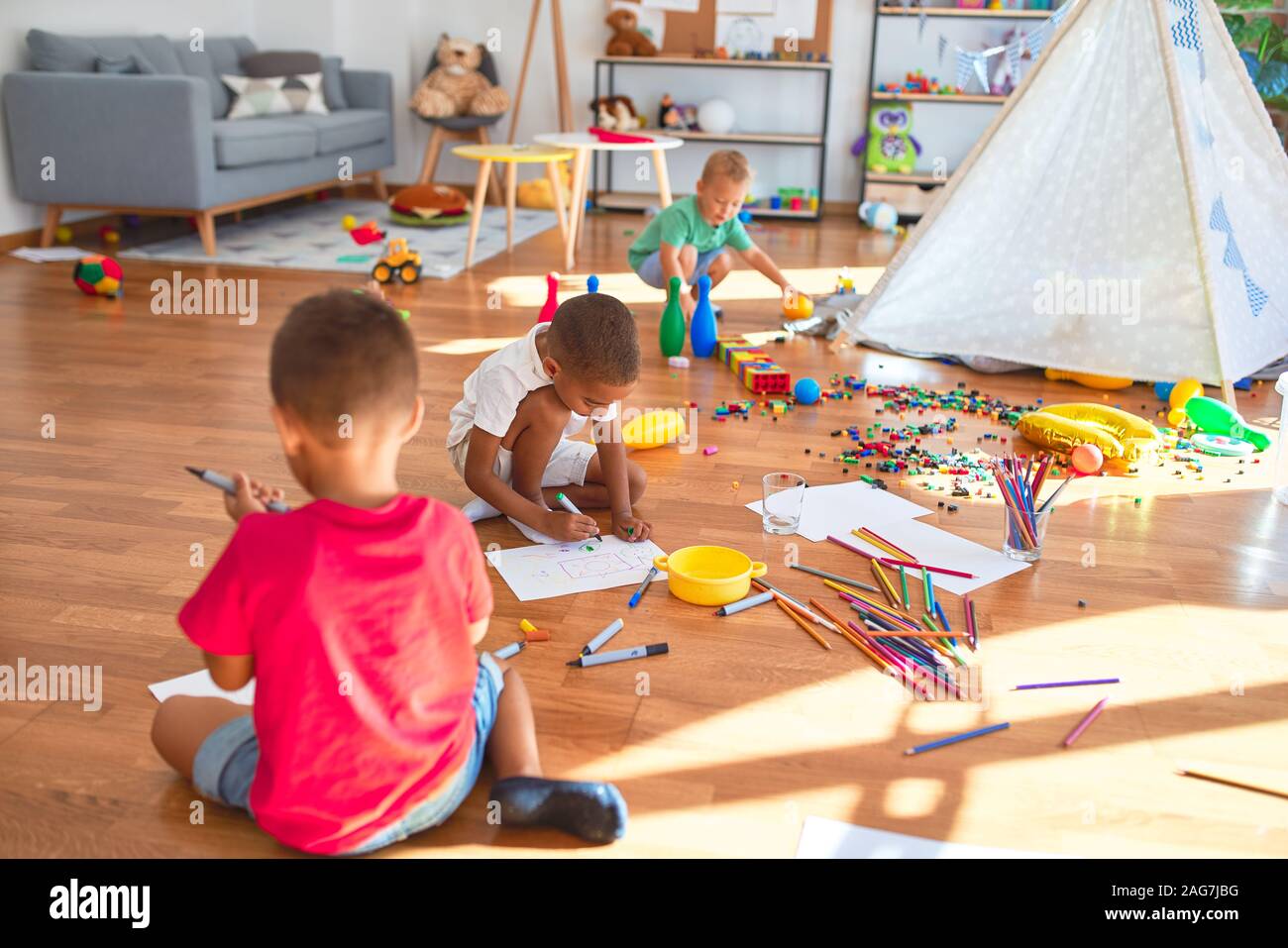 Adorable toddlers playing around lots of toys at kindergarten Stock ...
