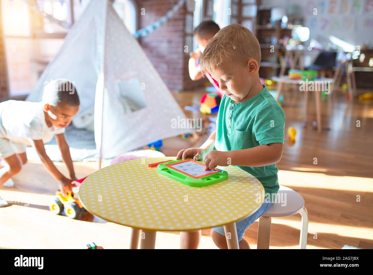 Adorable toddlers playing around lots of toys at kindergarten Stock ...