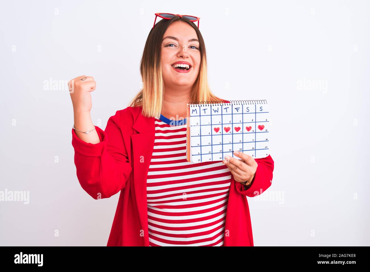 Young beautiful woman holding period calendar standing over isolated ...