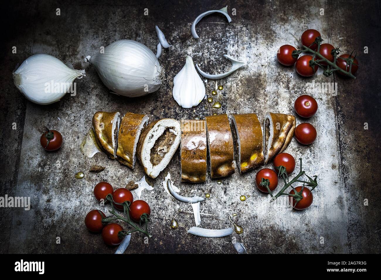 High angle shot of a meat pie split into many pieces with onions and ...
