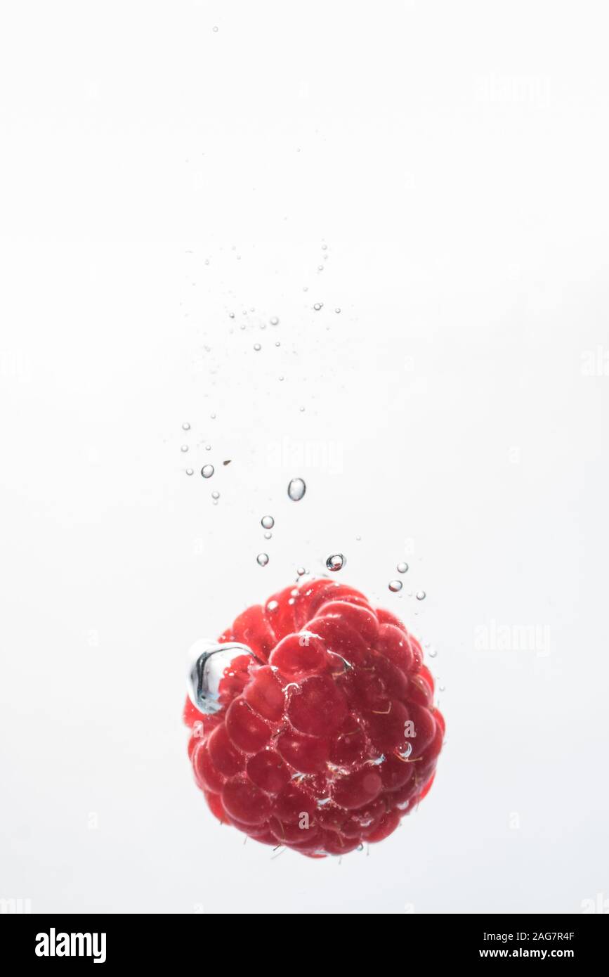Raspberry falling into a water Stock Photo - Alamy
