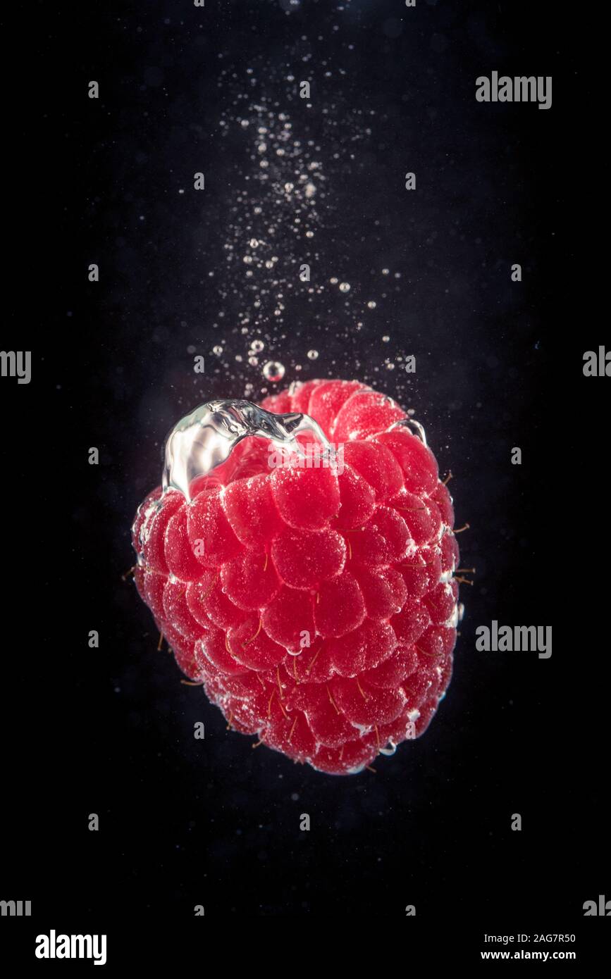 Raspberry falling into a water Stock Photo - Alamy