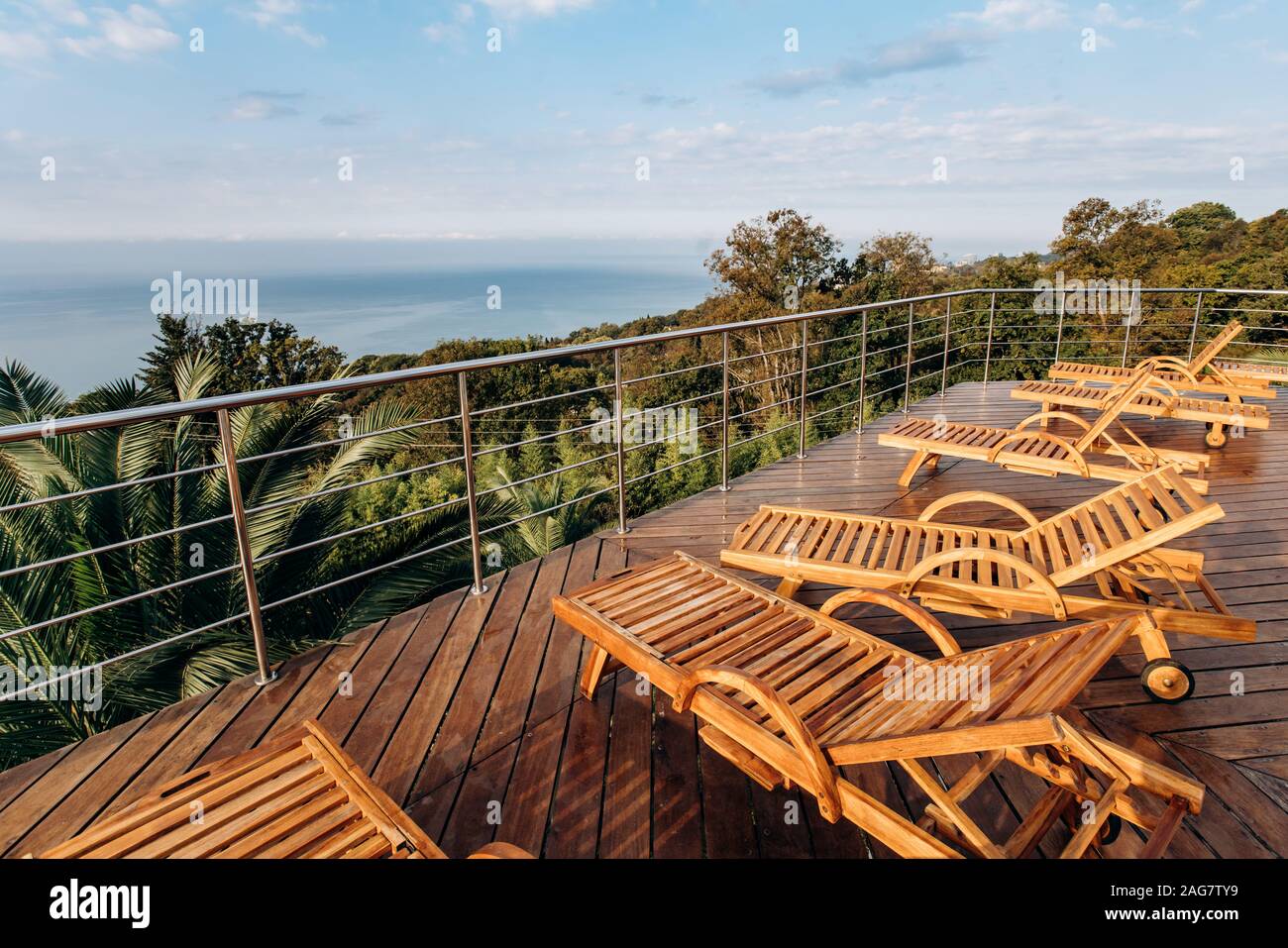 Wooden deck chairs in the hotel with scenic views of the ocean or sea ...