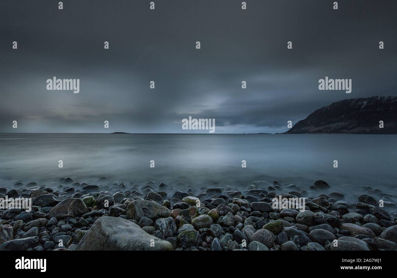 Calm morning at the beach with cold colors of the sky reflecting in the ...