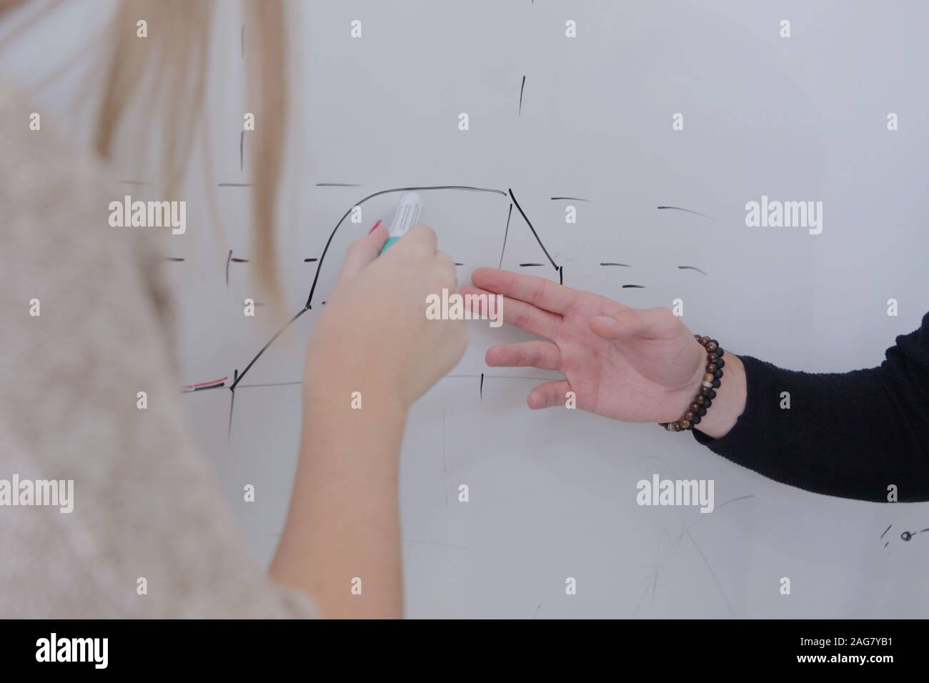 Two young college male and female students writting on the chalkboard ...