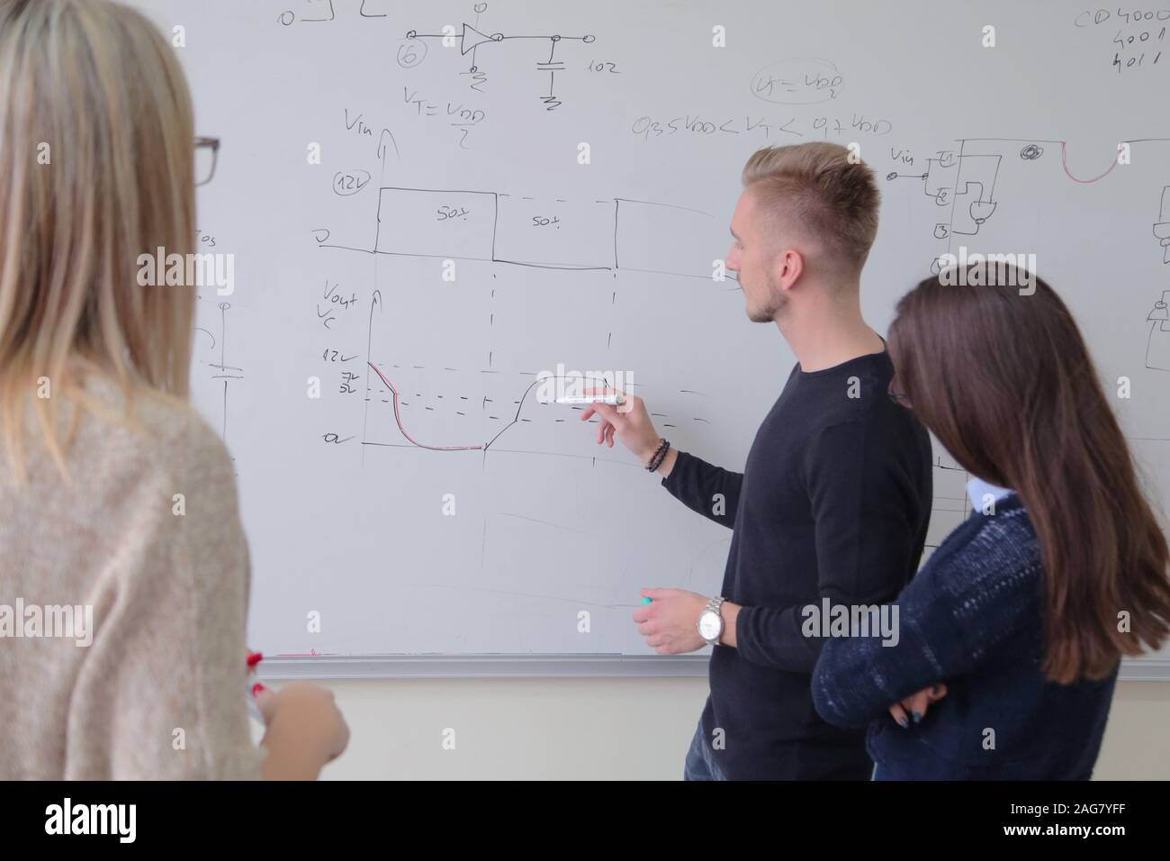 Two young college male and female students with young female teacher ...