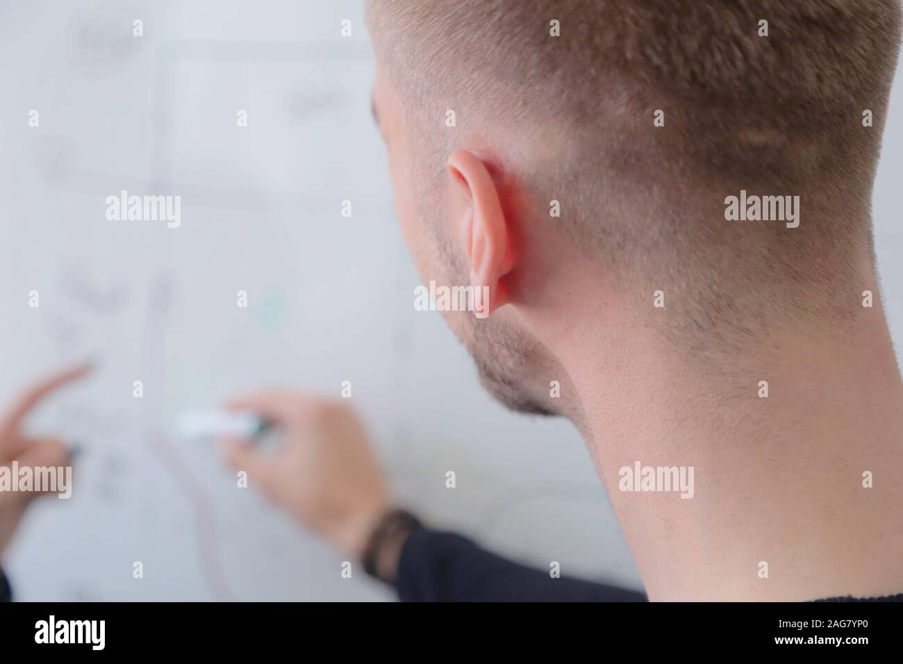 Two young college male and female students writting on the chalkboard ...