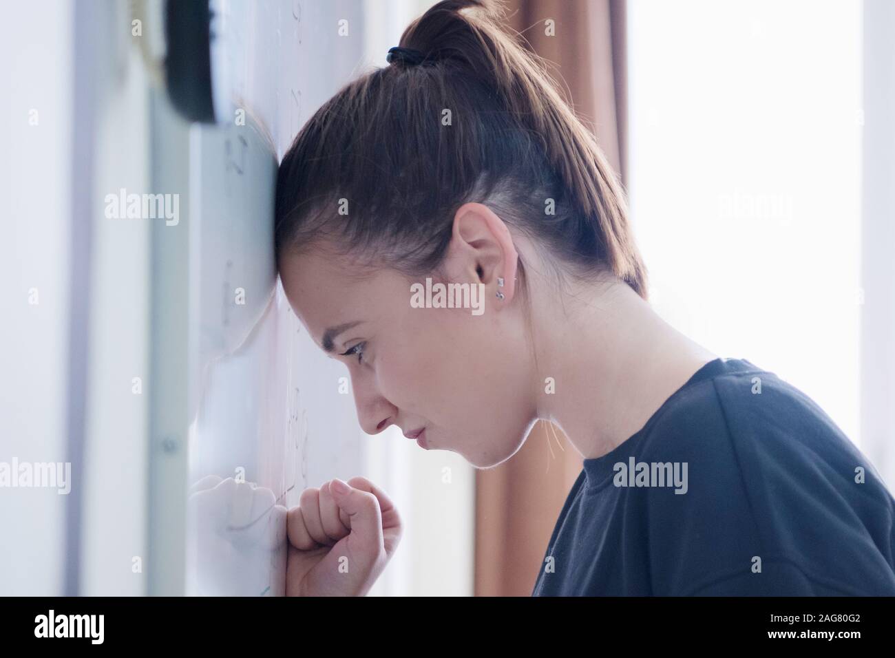 Young female student in math class overwhelmed by the math formula ...