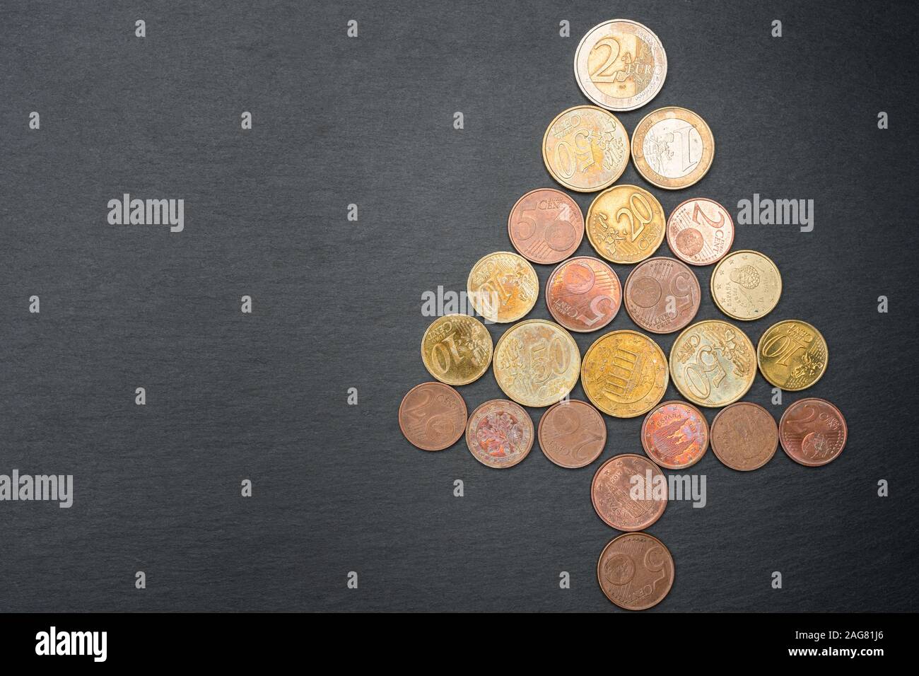 Christmas tree made out of Euro coins on dark black slate plate ...