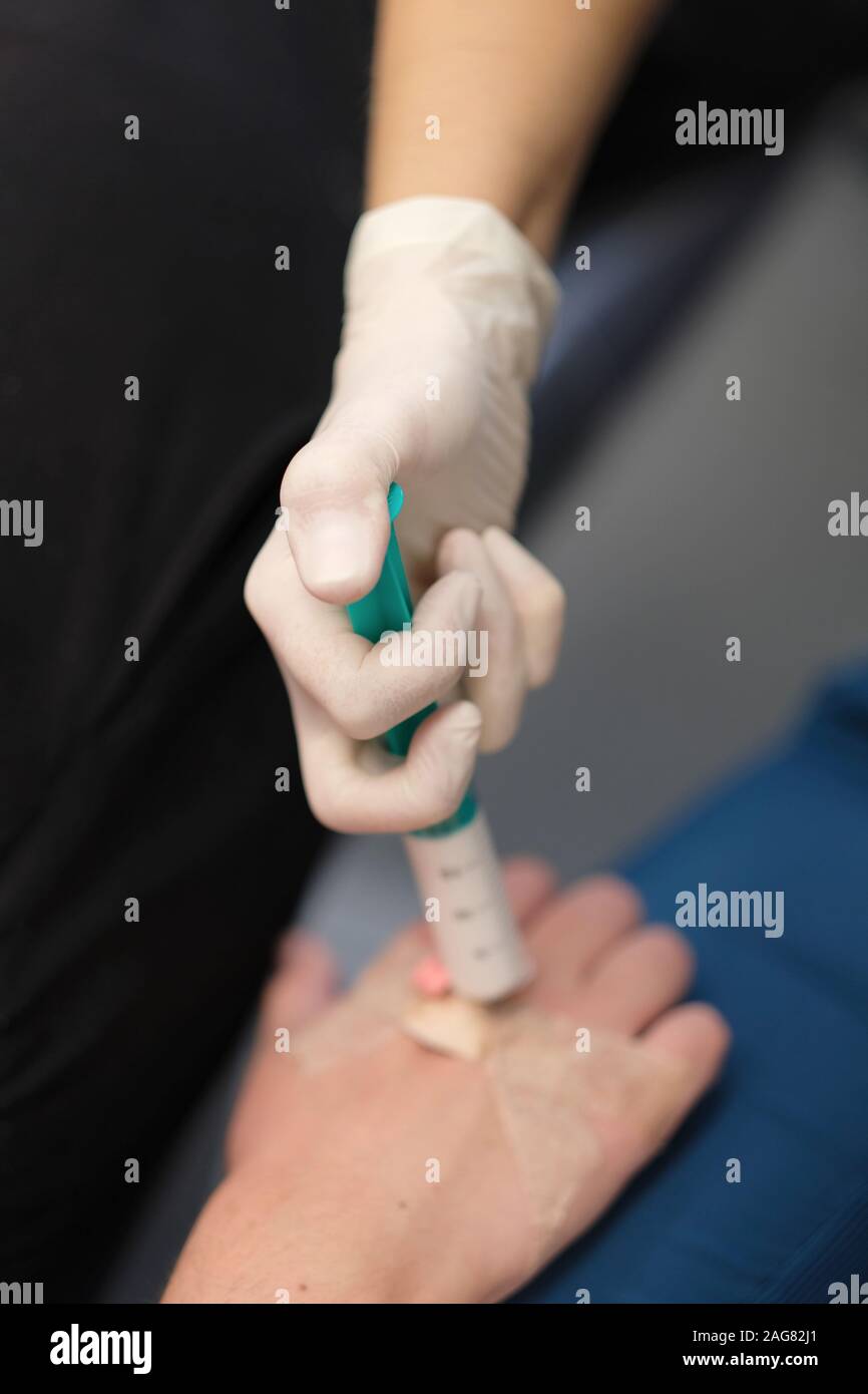 The doctor anesthesiologist injects the sedative intravenously into the ...