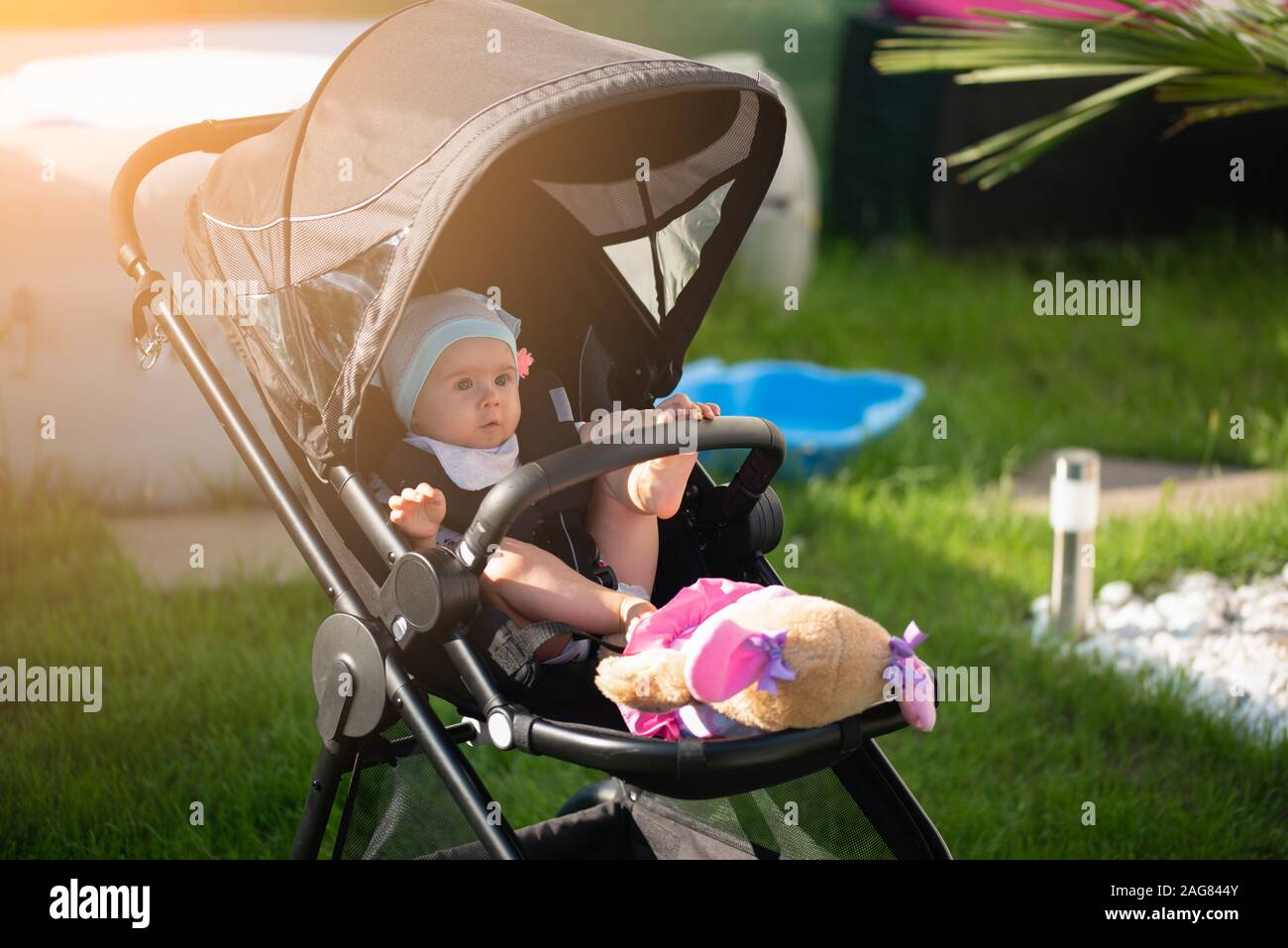 Baby in sitting stroller in garden Stock Photo - Alamy