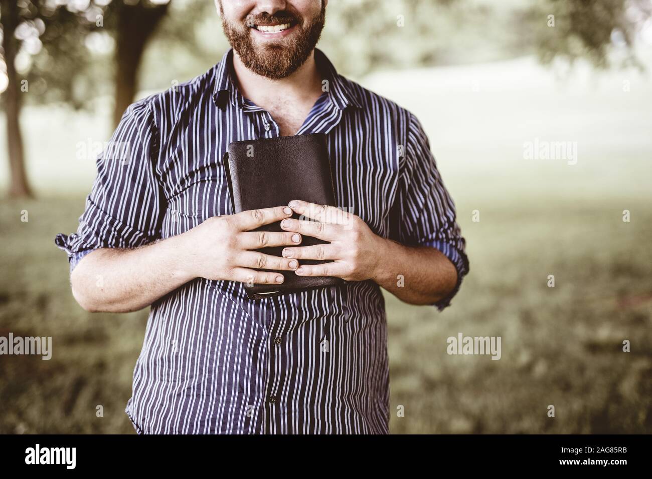 Smiling man holding bible hi-res stock photography and images - Alamy