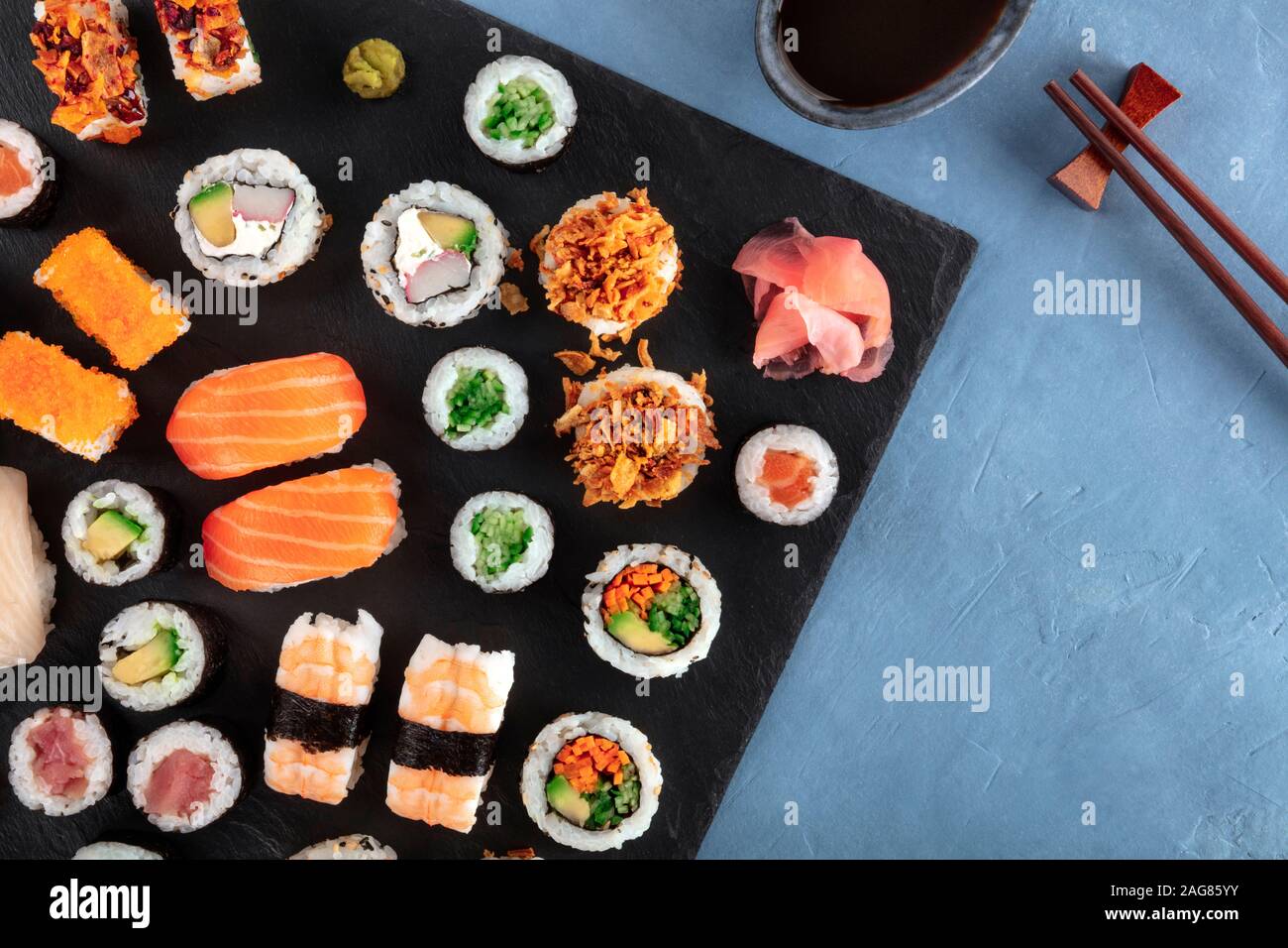 Large sushi set, shot from above on a slate background with chopsticks ...