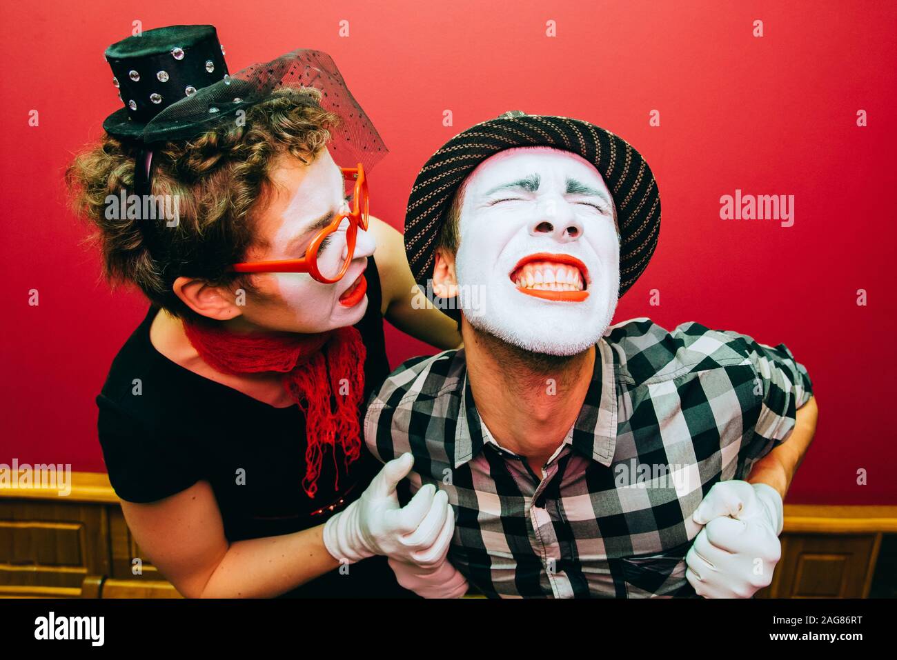 two mimes showing emotions on the wall background Stock Photo - Alamy