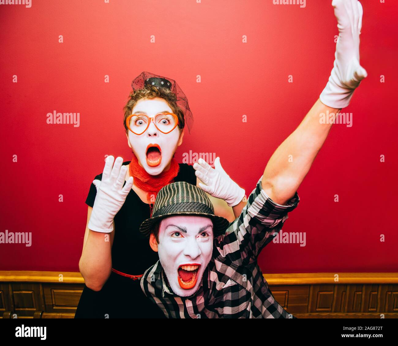 two mimes showing emotions on the wall background Stock Photo - Alamy