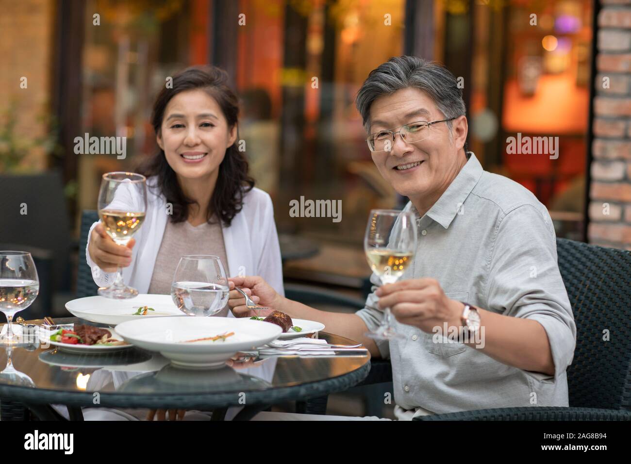 Mature Chinese couple toasting at restaurant Stock Photo - Alamy