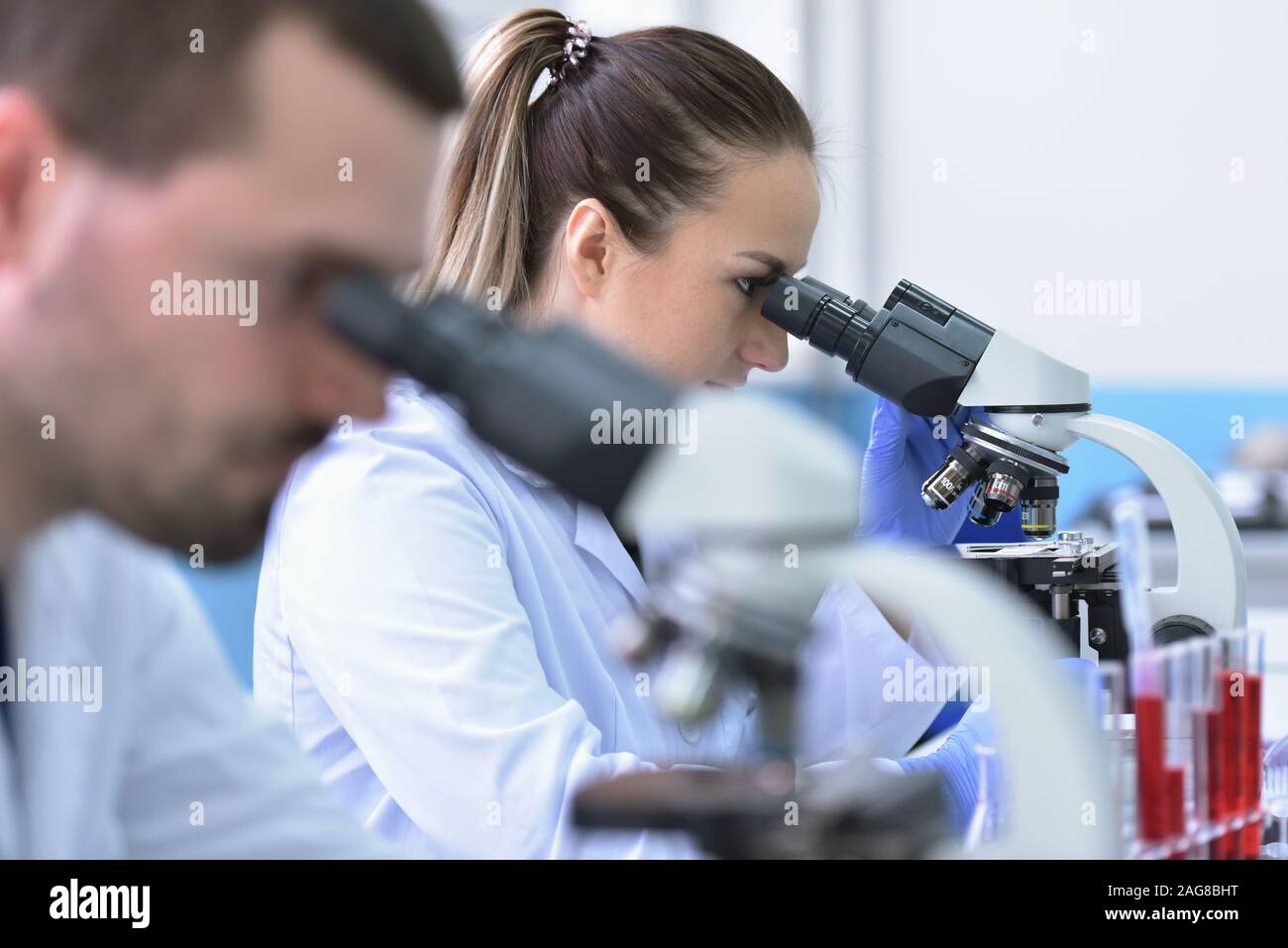 Two Young Female and male Laboratory scientists working at lab with ...
