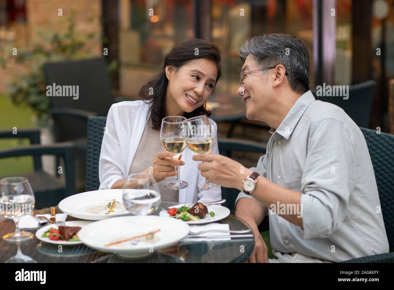 Mature Chinese couple toasting at restaurant Stock Photo - Alamy