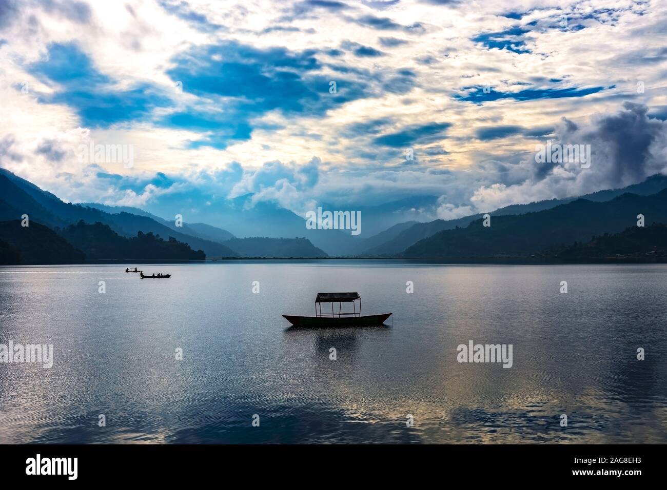 A single row Boat parked in middle of Phewa Lake and clouds on the sky ...