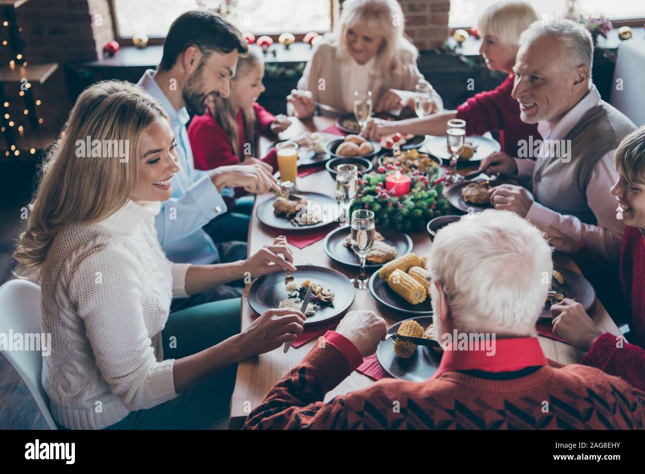 Photo of full family gathering sitting around dinner table ...