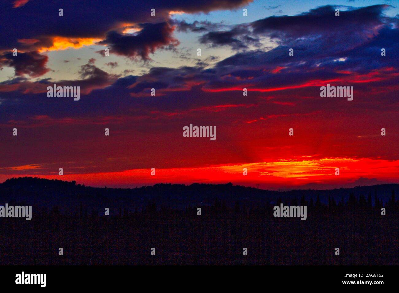 Breathtaking shot of the red sky during the sunset above silhouettes of ...