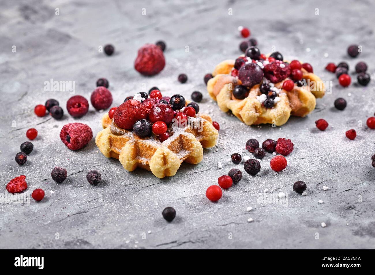 Fresh small round waffles topped with fruits like blueberry and ...