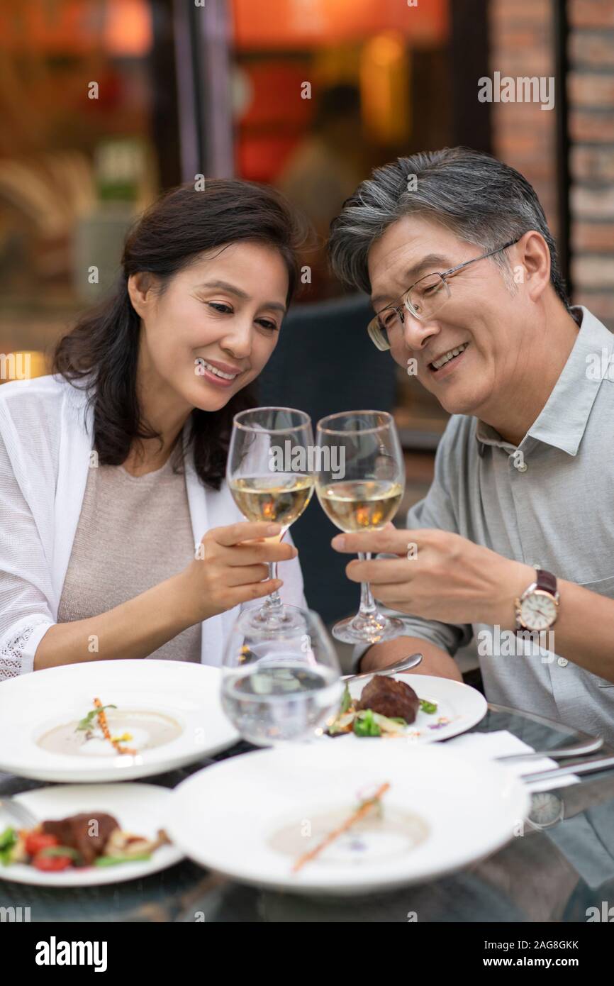 Mature Chinese couple toasting at restaurant Stock Photo - Alamy