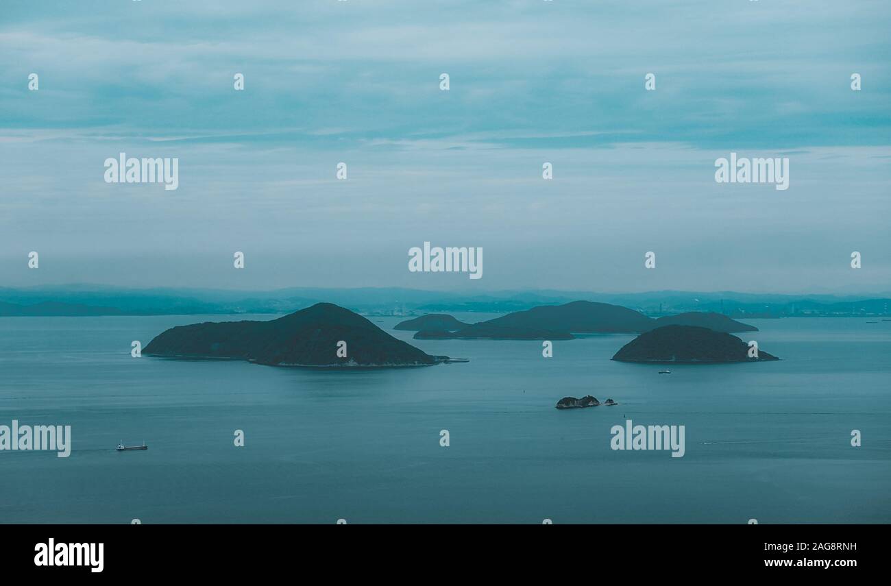 Beautiful shot of Islands of Japan enveloped in fog under the cloudy ...