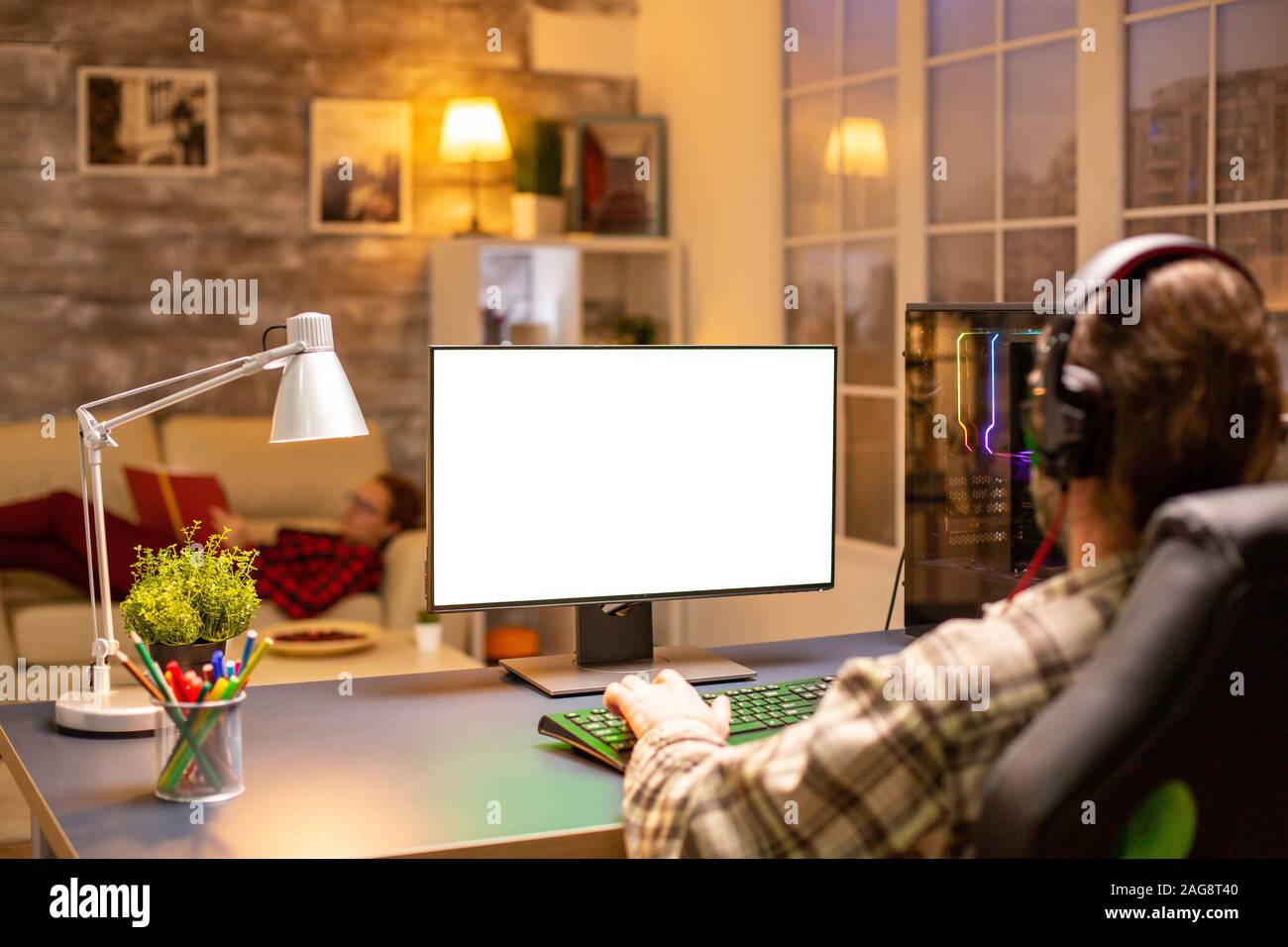 Back view of professional gamer looking at computer with isolated mock ...