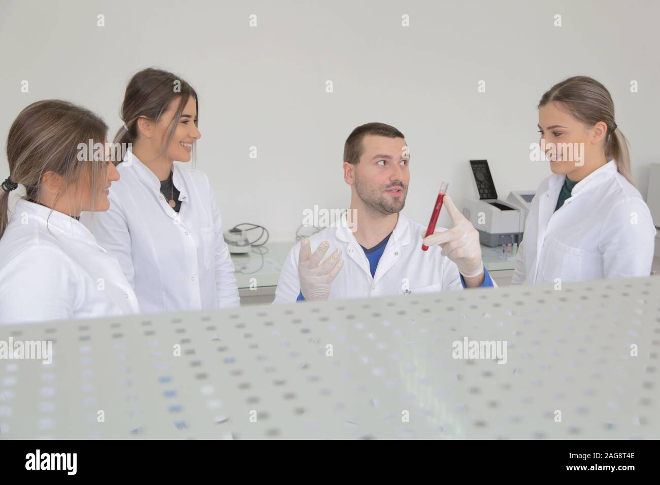 Group of young Laboratory scientists working at lab with test tubes and ...