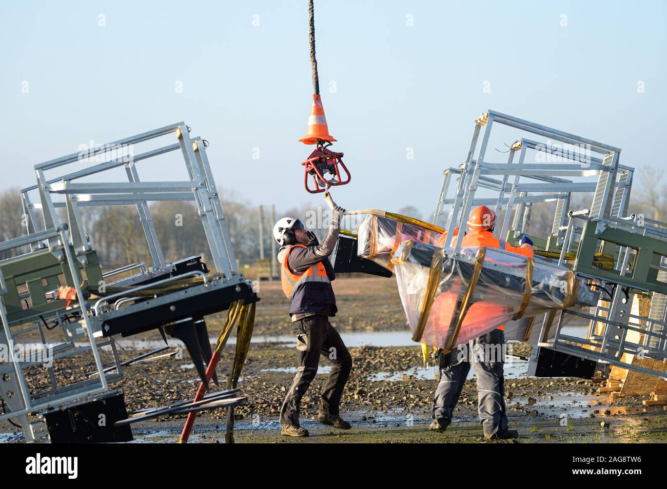 Sande, Germany. 18th Dec, 2019. Workers attach a route signal to the ...
