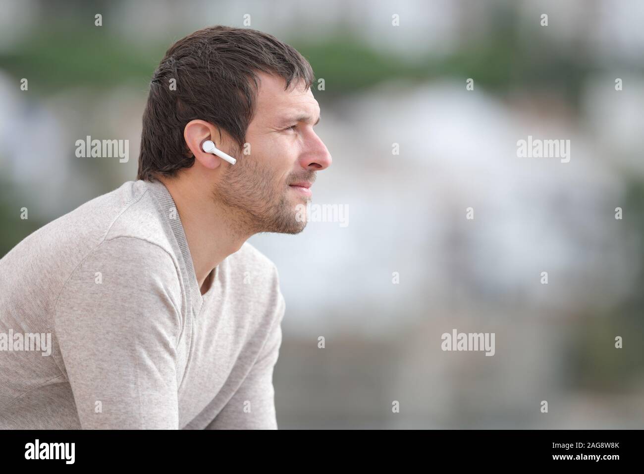 Side view portrait of a serious man listening to music with wireless ...