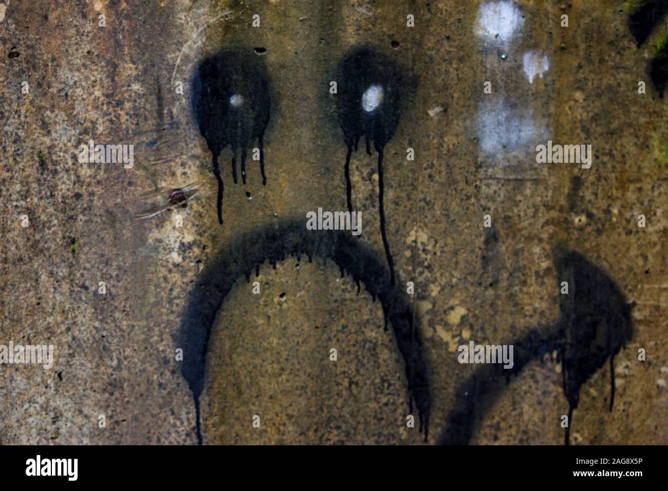 Illustration of a sad crying face on a wall made painted with black ...