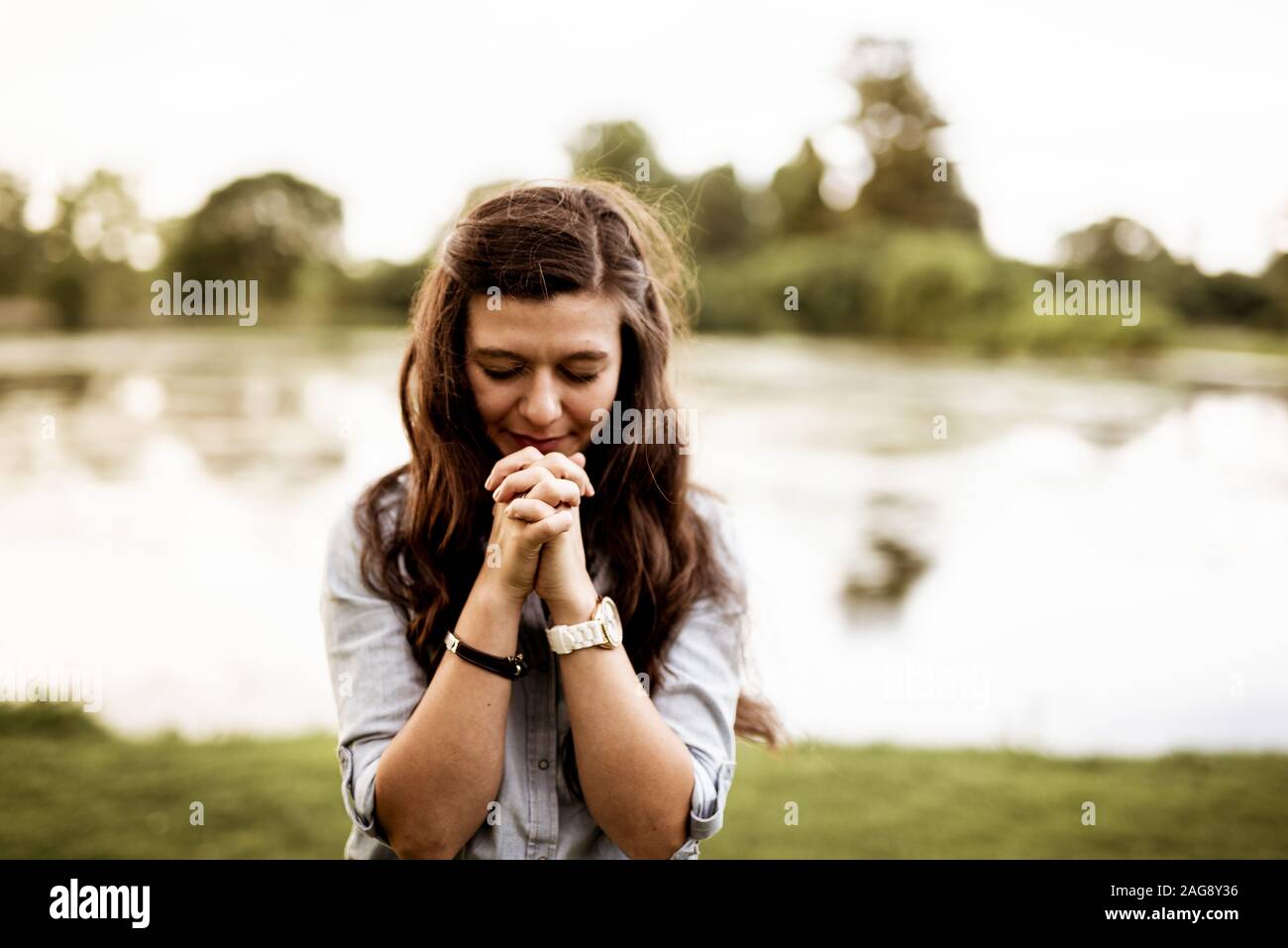 Closeup shot of a female with her eyes closed while praying with a ...