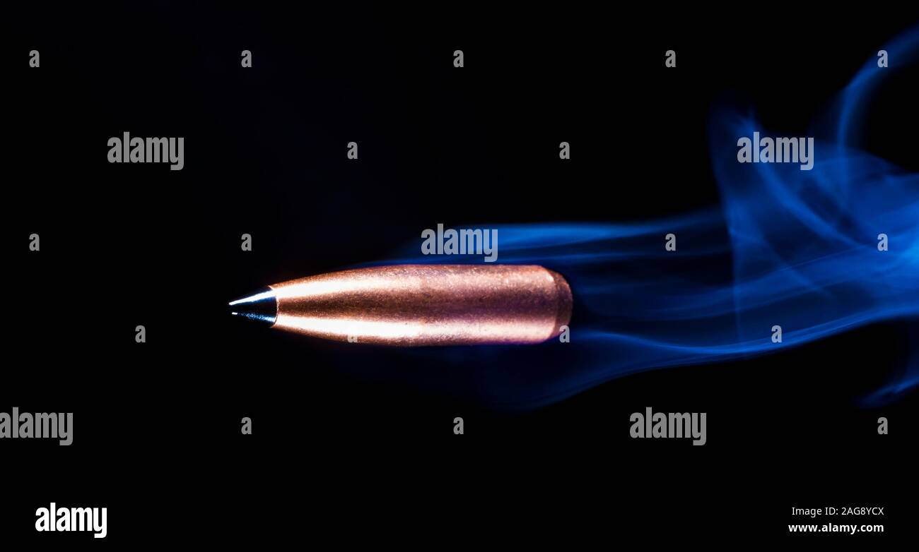 Copper bullet with polymer tip on a black background with smoke Stock ...