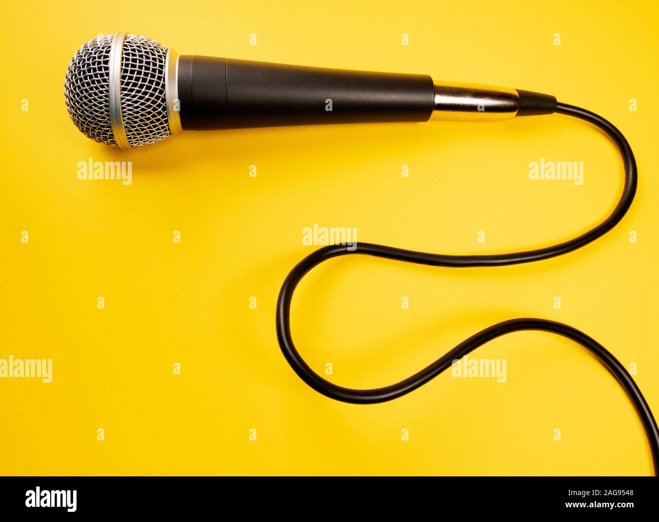 Microphone with curly cable on yellow background Stock Photo - Alamy