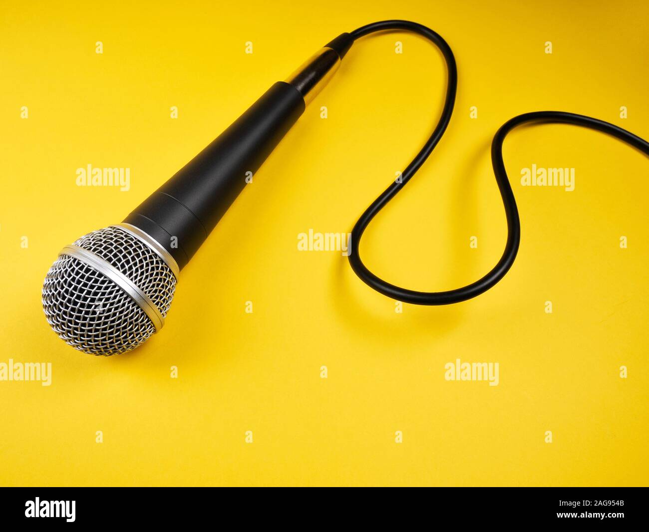 Microphone with curly cable on yellow background Stock Photo - Alamy