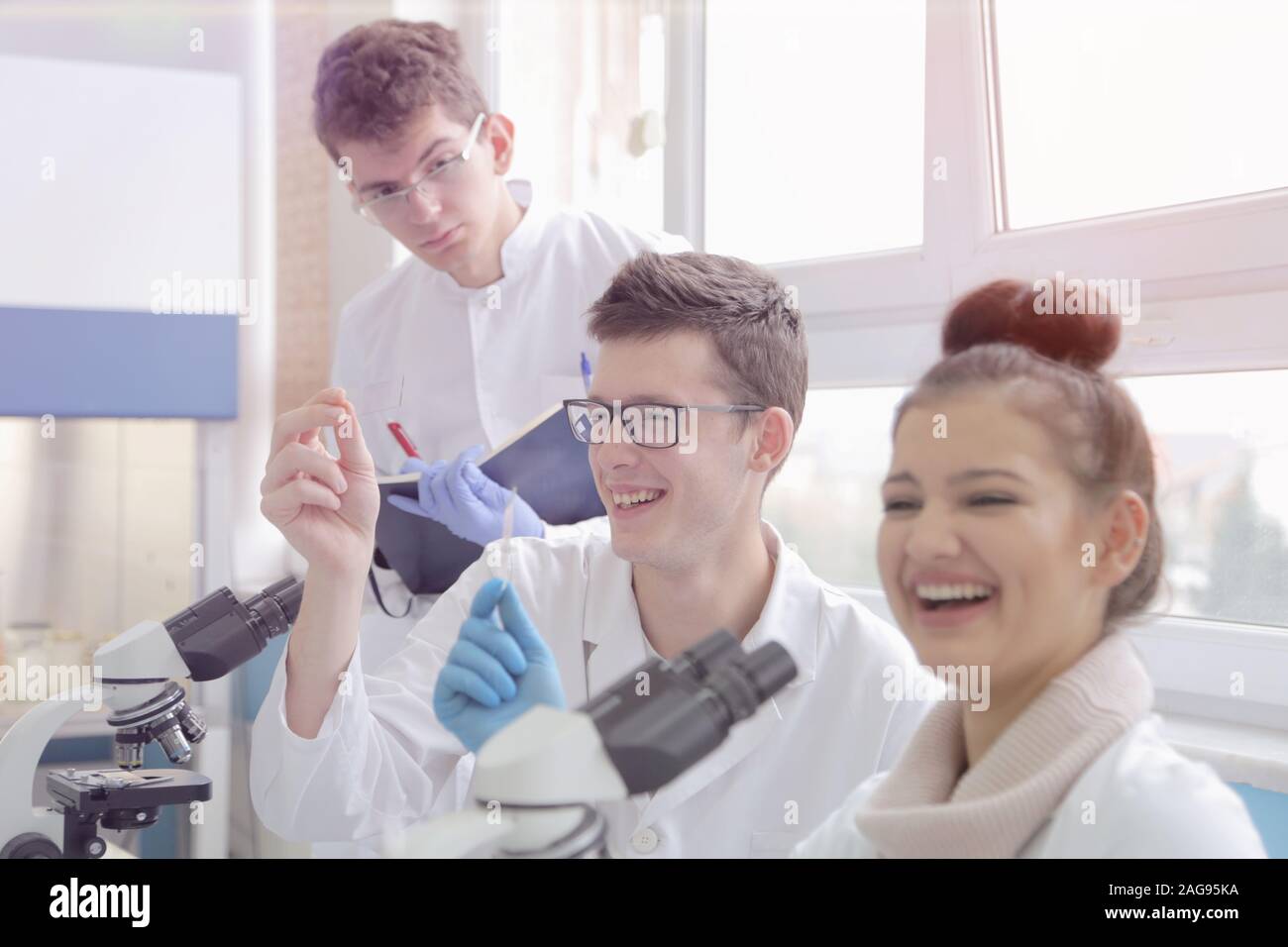 Group of young Laboratory scientists working at lab with test tubes and ...