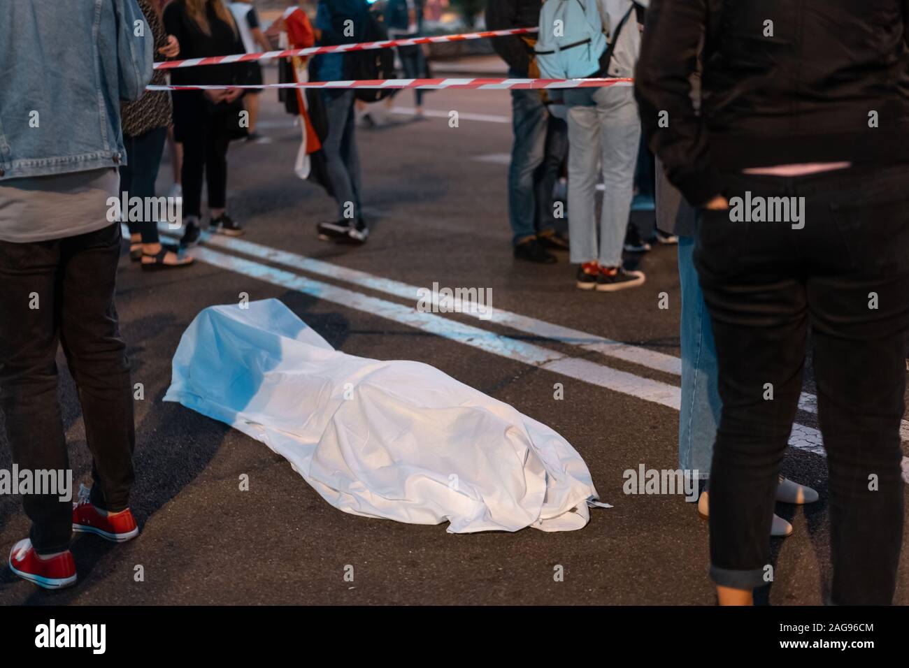 Human body covered by a sheet lying on the street Stock Photo - Alamy