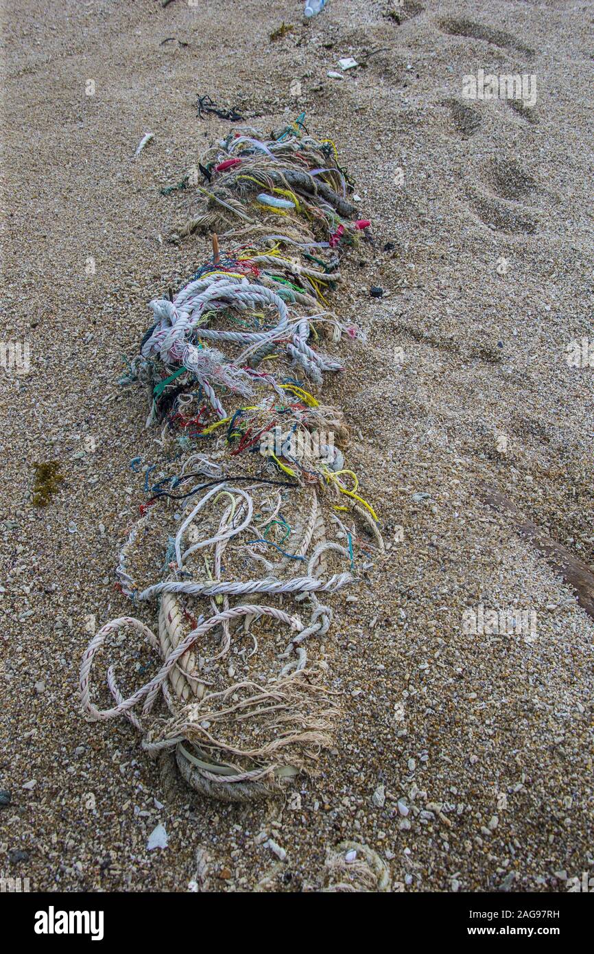 Vertical high angle shot of colorful threads buried in the sand of the ...