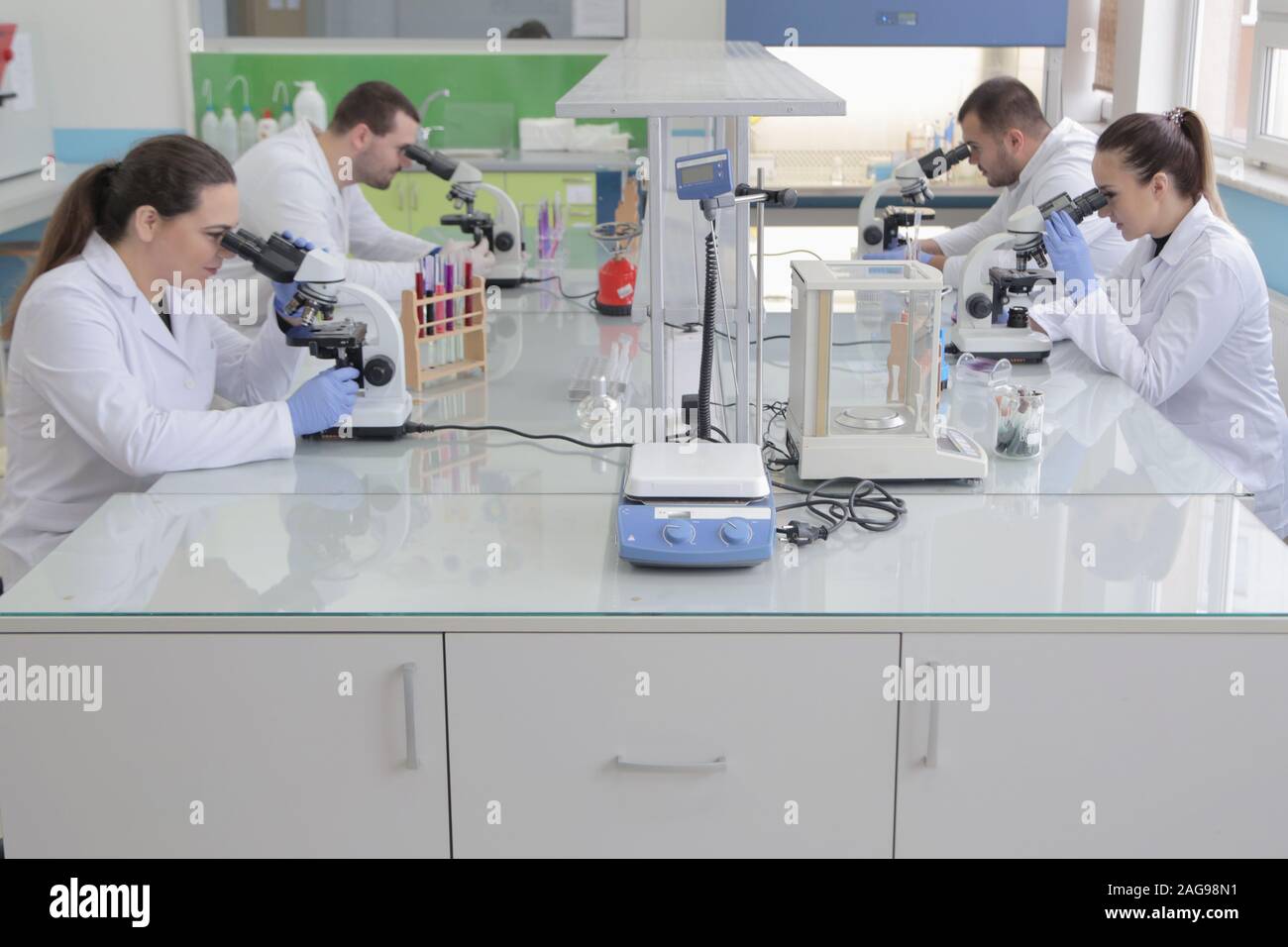 Group of young Laboratory scientists working at lab with test tubes and ...