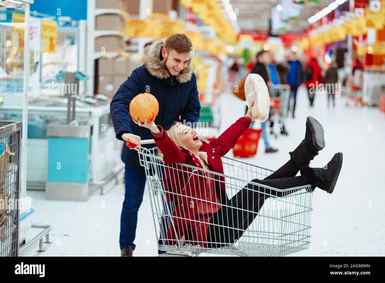 Young handsome guy rides a girl in a supermarket in a trolley Stock ...