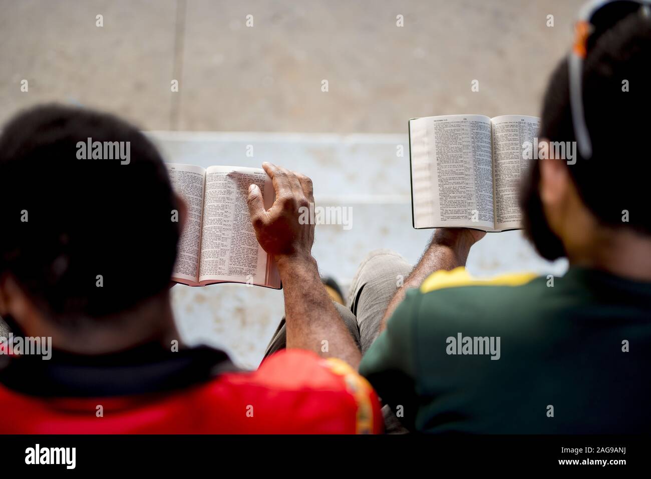 Overhead shot of people sitting and reading the bible with a blurred ...