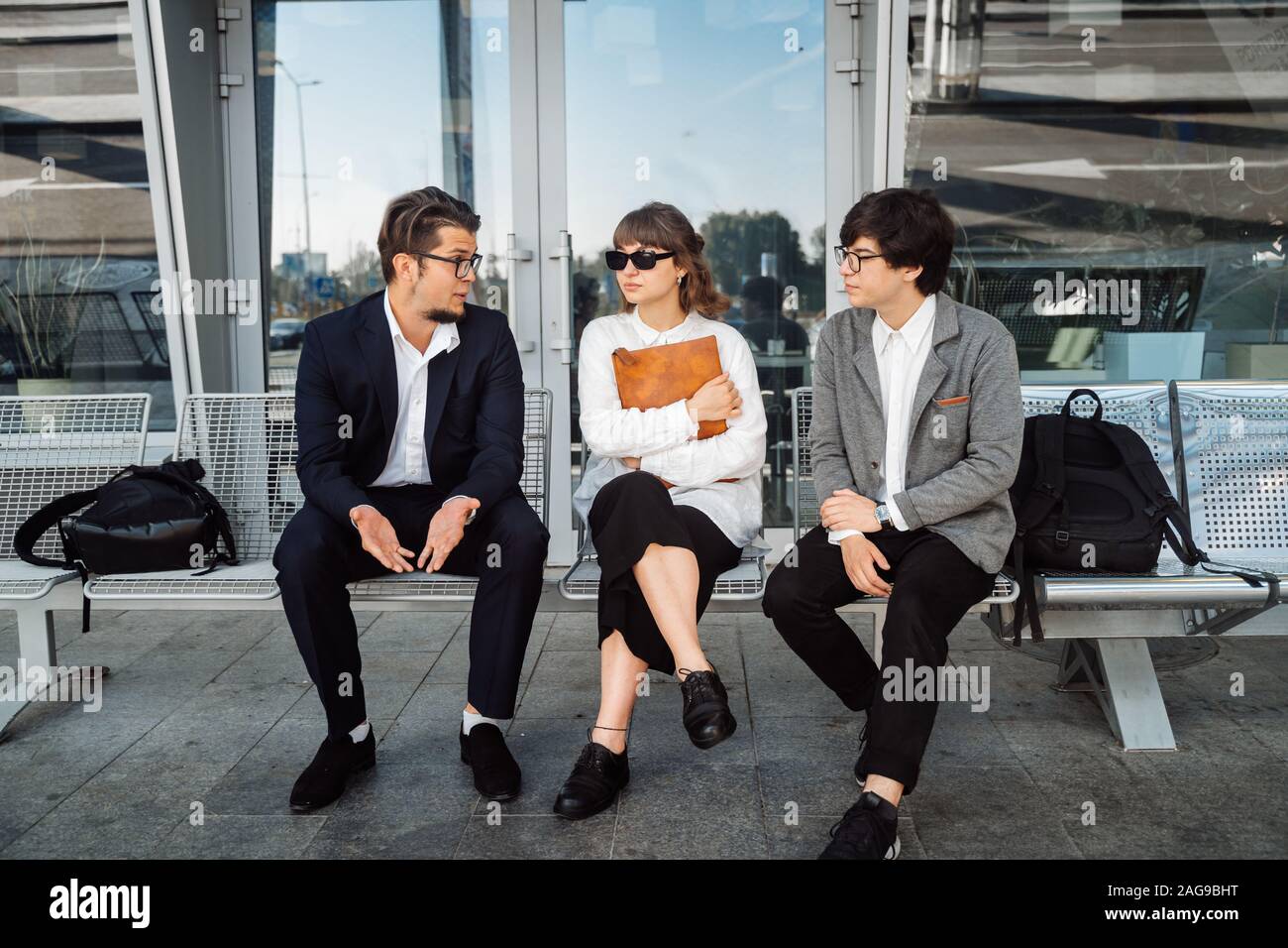 Two businessmen and a secretary discuss an important issue outside ...