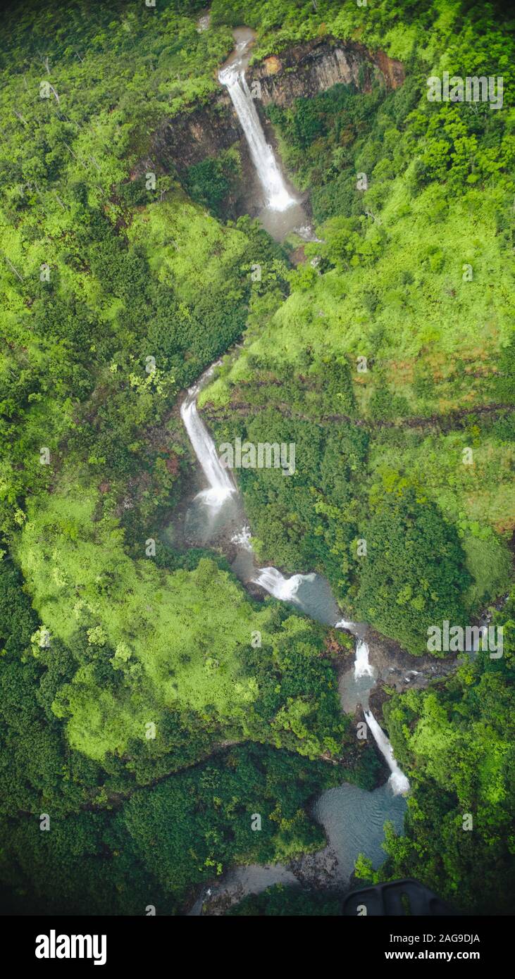 Vertical high angle shot of the waterfalls among the forest captured in ...