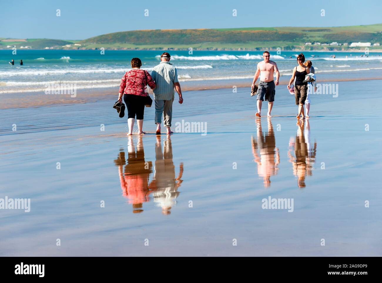 People walking along the beach, with reflections in the wet sand Stock ...
