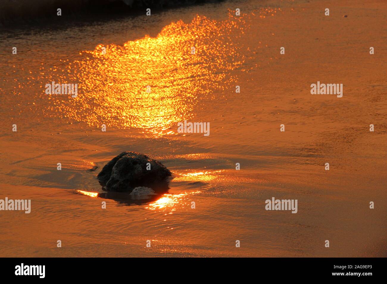 Big stone in the sea with the reflection of the sunset - great for a ...