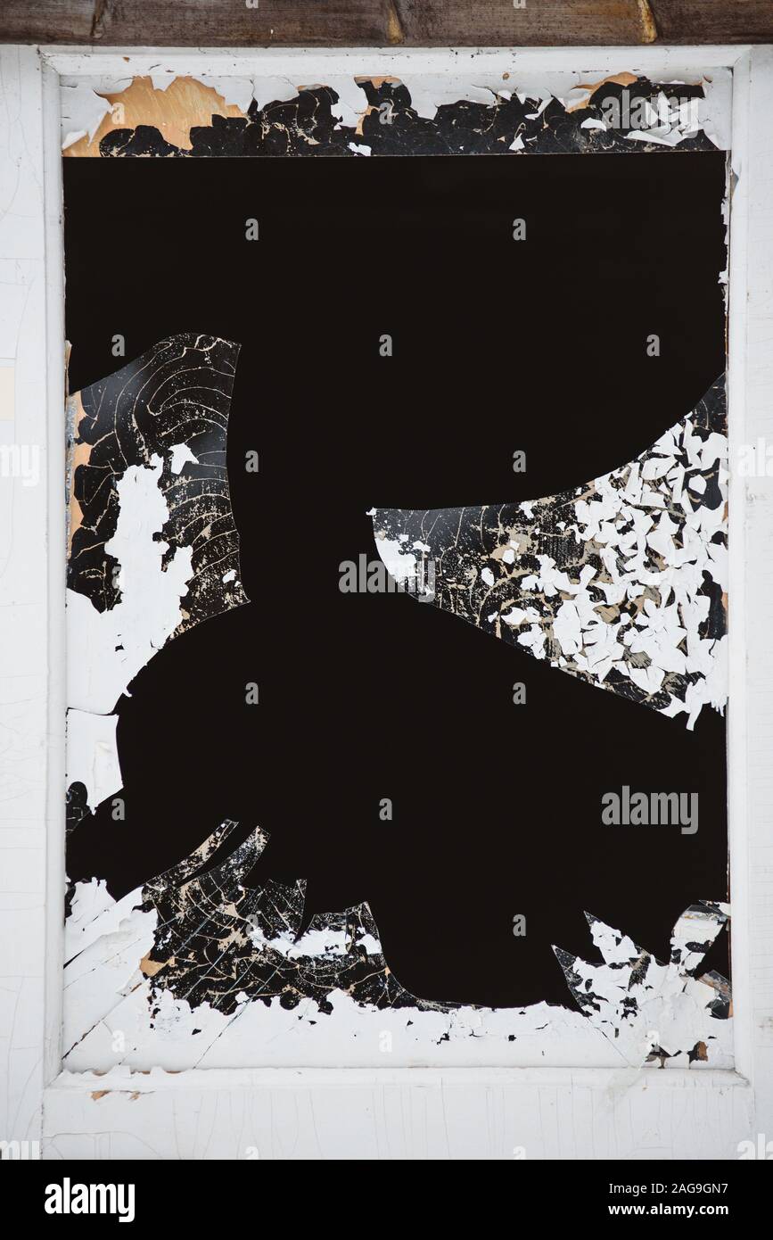 A broken window pane in the doorway, with sharp, dangerous edges of ...