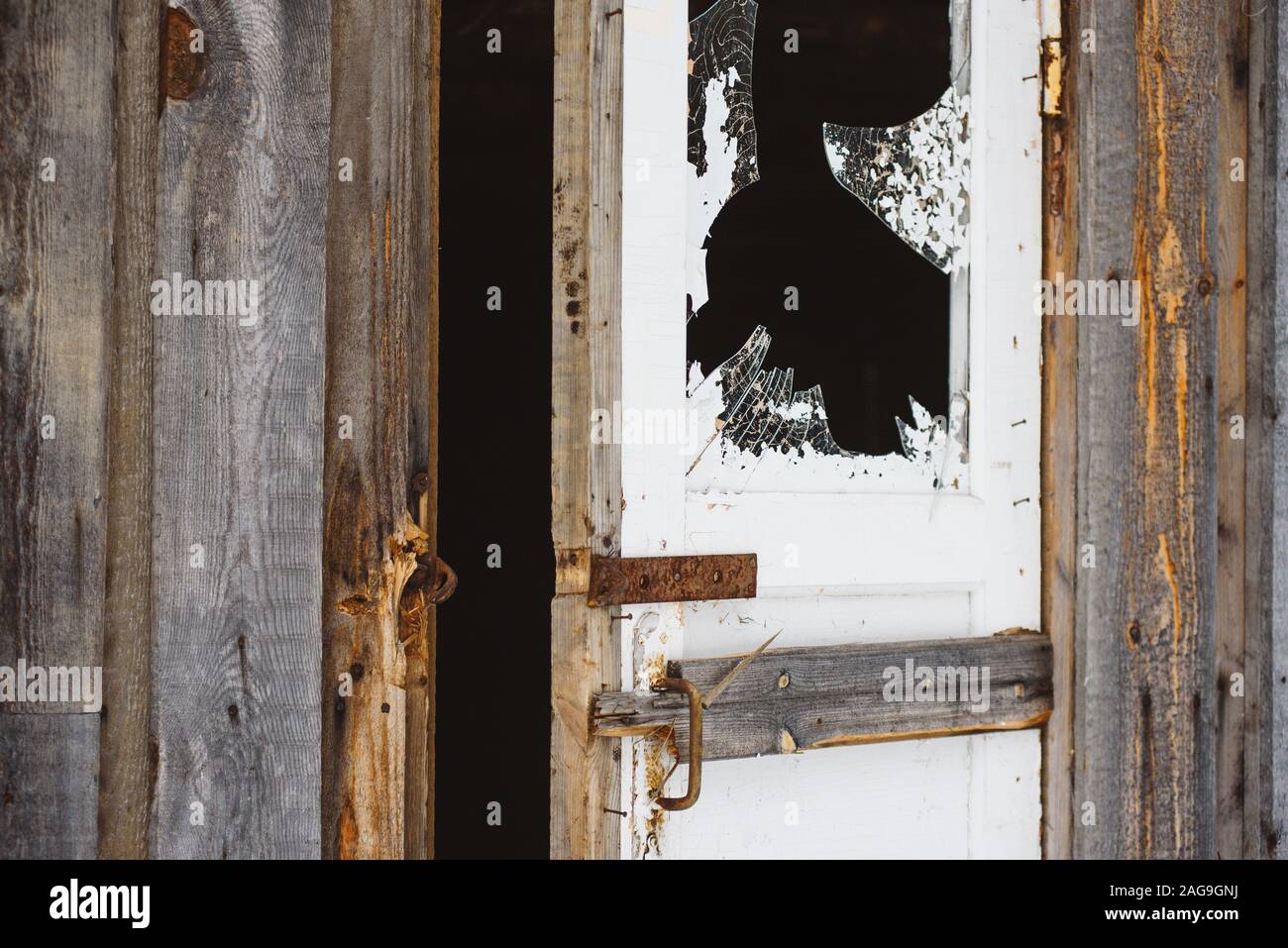 A broken window pane in the doorway, with sharp, dangerous edges of ...